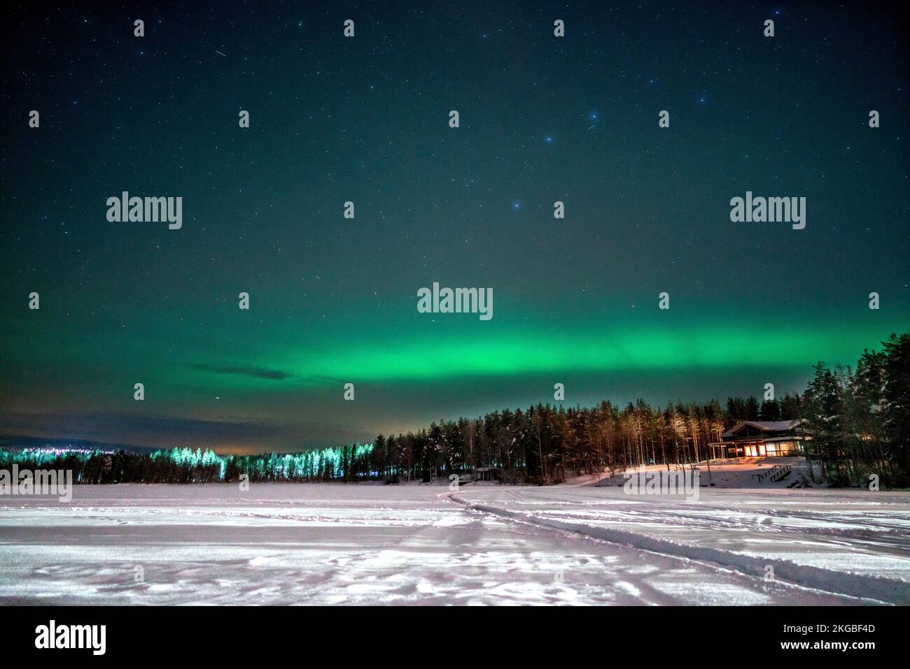 A panoramic view of the Aurora Borealis over a frozen lake in Lapland ...