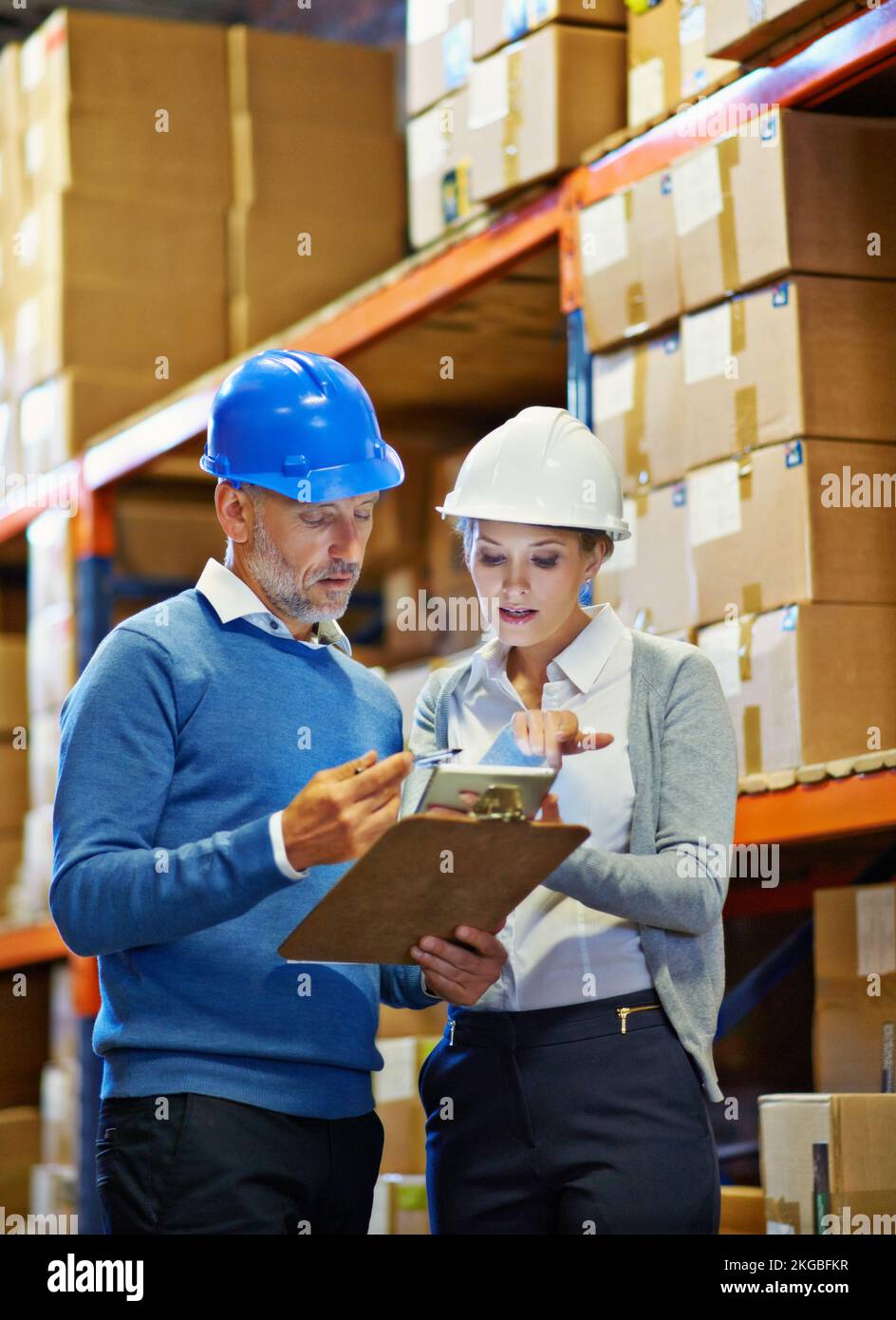 Checking old ways against new technology. two people doing an inventory ...