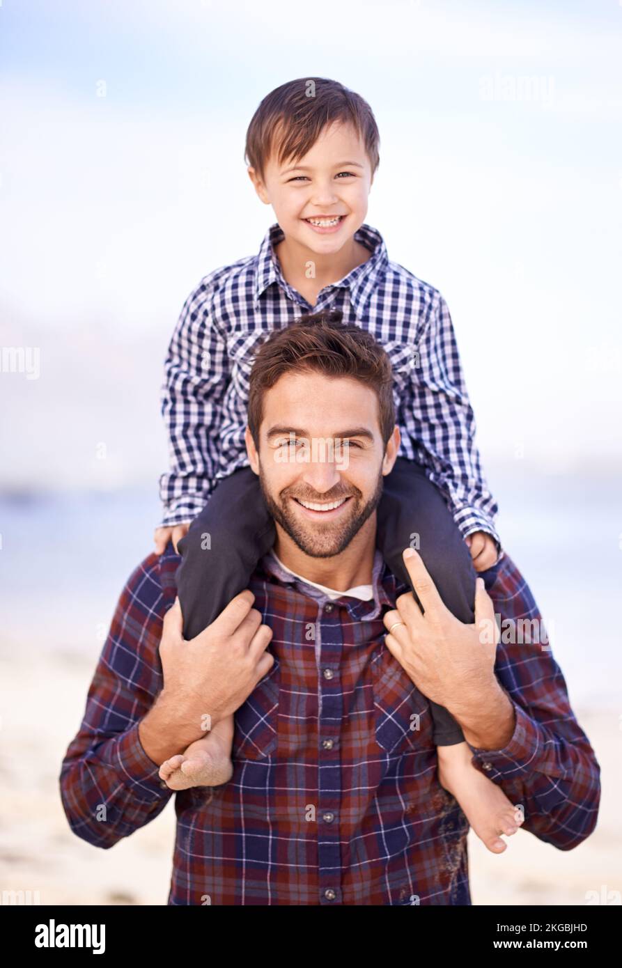Sharing matching smiles of enjoyment. A father carrying his young son ... Sharing matching smiles of enjoyment. A father carrying his young son ...