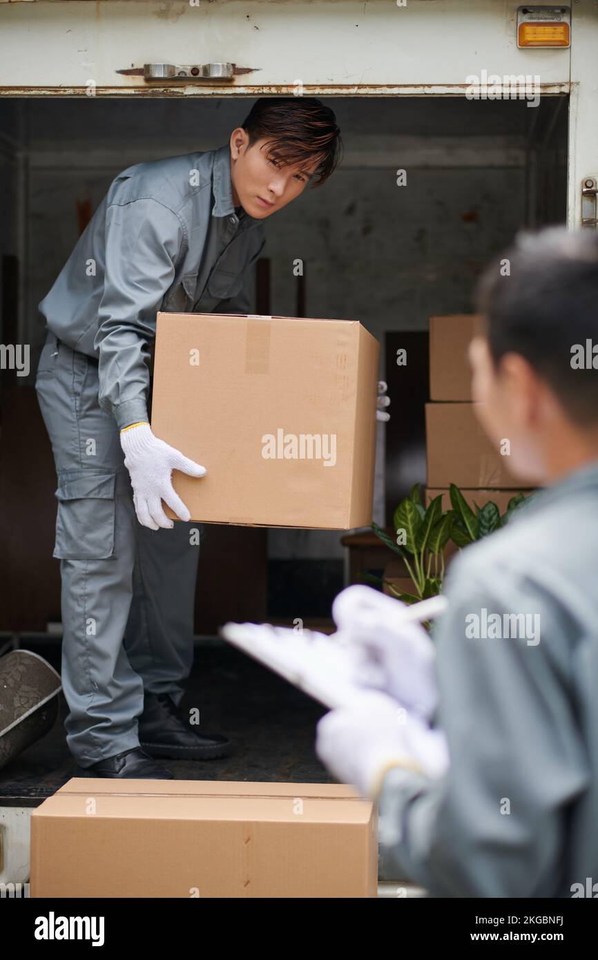 Mover loading boxes with belongings of client in van Stock Photo - Alamy