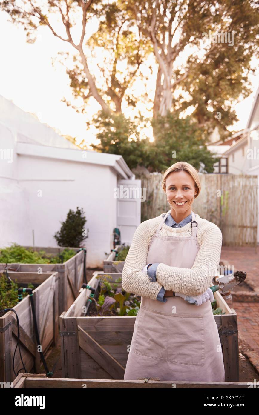 My happy place. Portrait of a beautiful woman gardening in the backyard ...