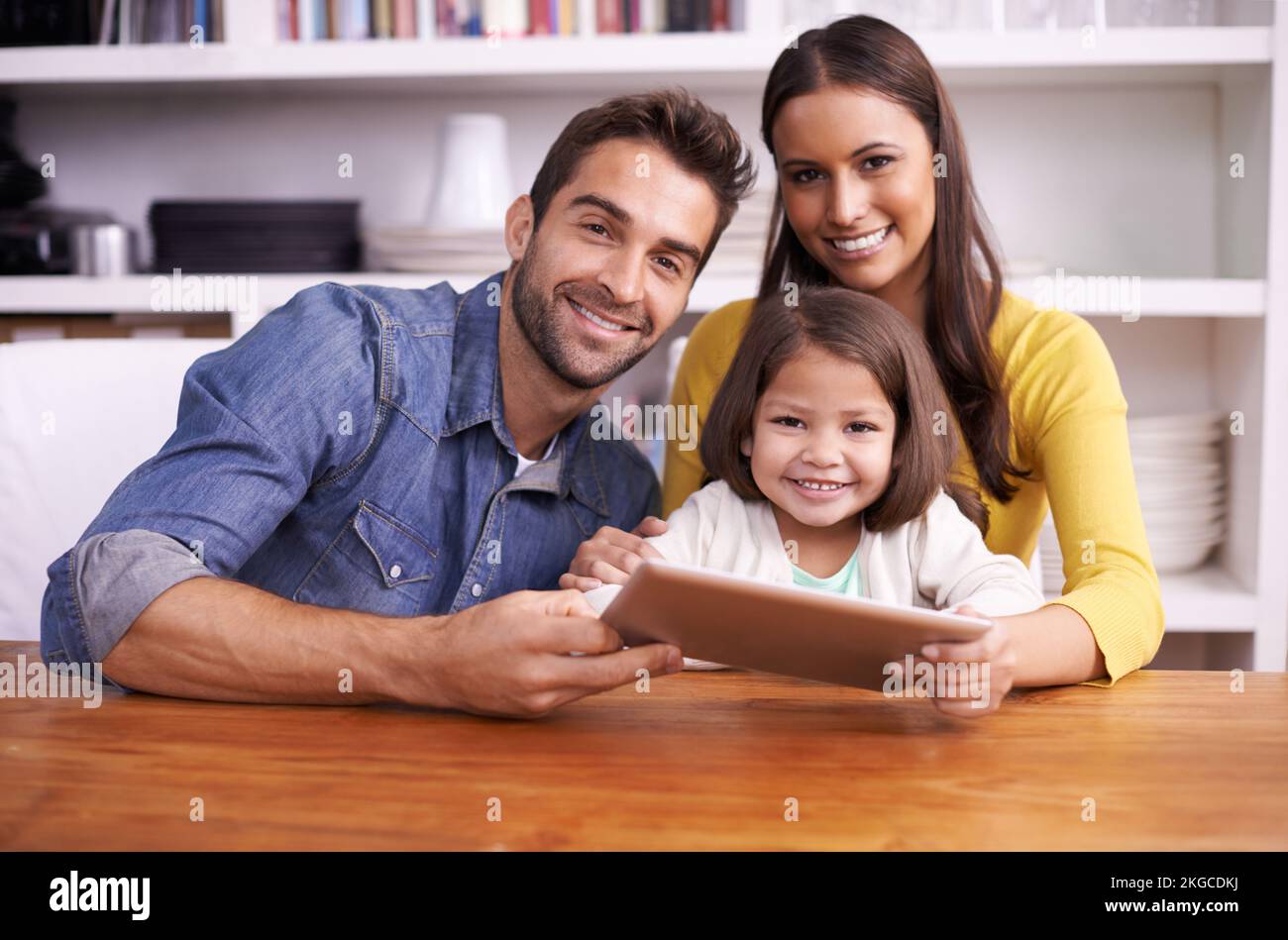 Techno friendly family. A little girl playing on a tablet with her ...