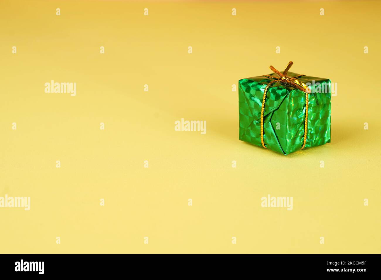 green gift box with gold string bow isolated on yellow background Stock ...