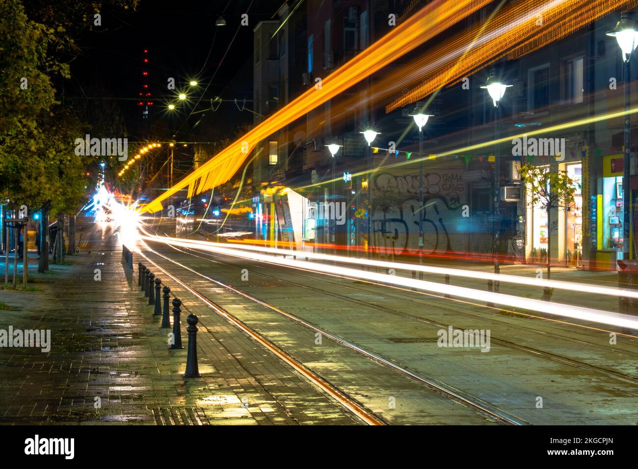 Night scene of tram in traffic at crossing with lighttrail Stock Photo ...