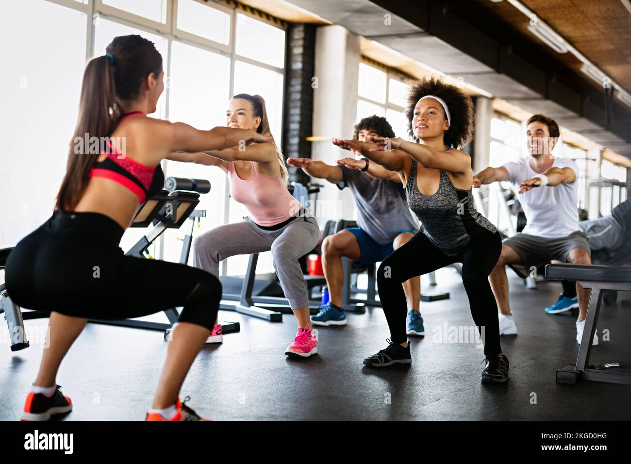 Multiethnic group of people training in a gym. Trainer and sportive fit ...