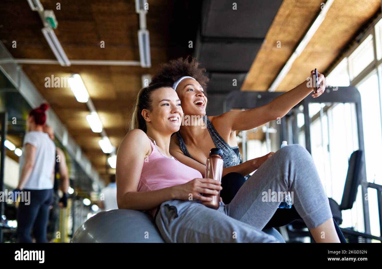 Happy fit women, friends smiling, talking and taking photos after work ...