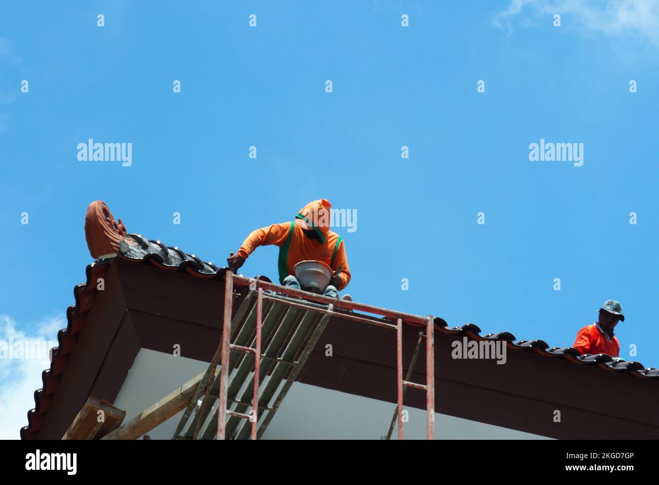 construction workers fixing roof against clouds blue sky, install ...