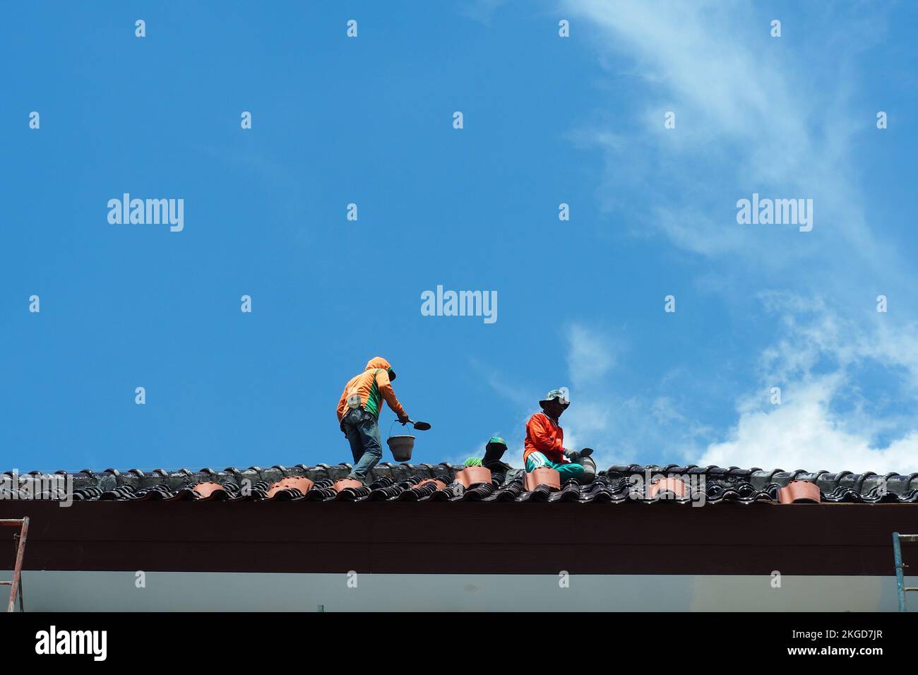 construction workers fixing roof against clouds blue sky, install ...