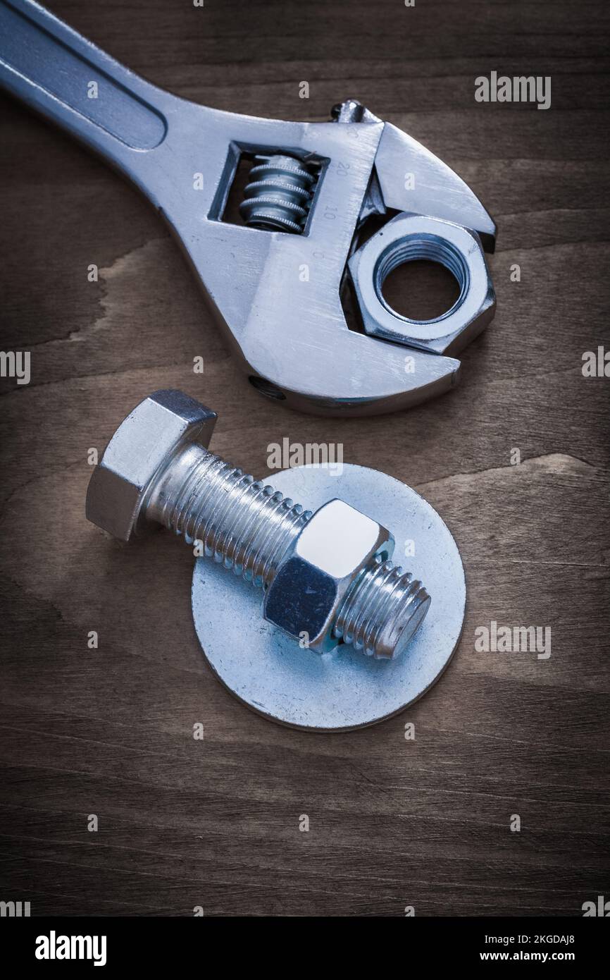 Adjustable key bolt washer screw-nut and bolt on wooden background ...