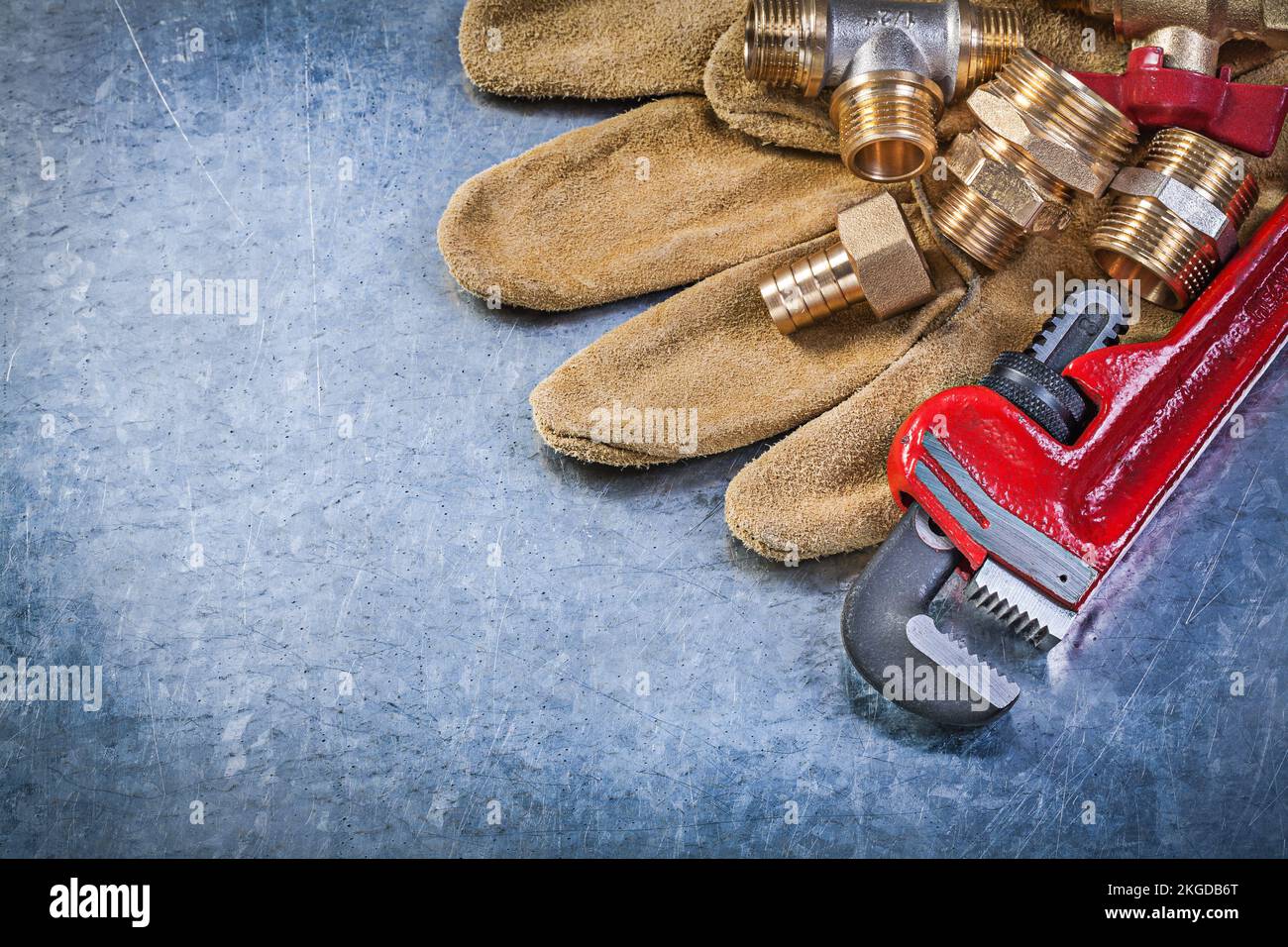 Adjustable wrench protective gloves brass pipe connectors on metallic ...