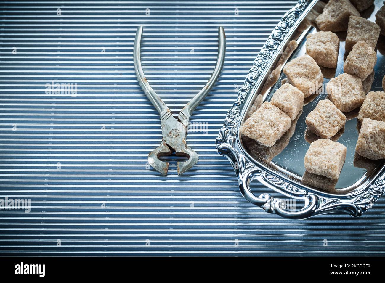 Brown sugar pliers tray on striped background Stock Photo - Alamy