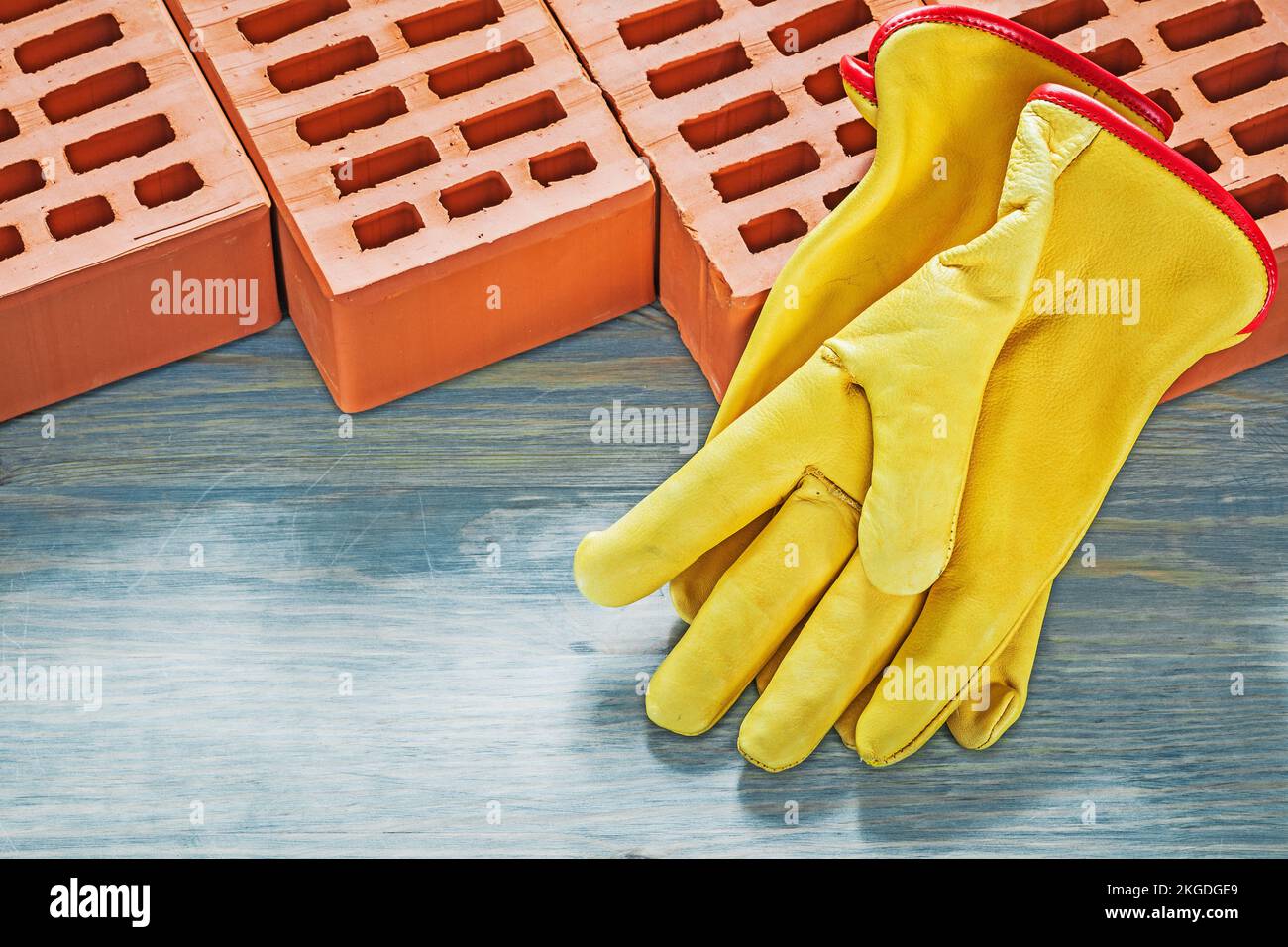 Building bricks yellow protective gloves on wooden board bricklaying ...