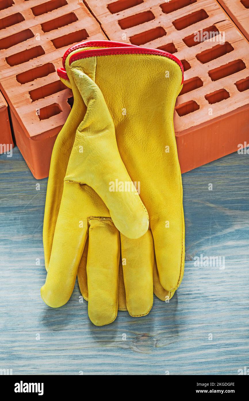 Building bricks yellow protective gloves on wooden board construction ...
