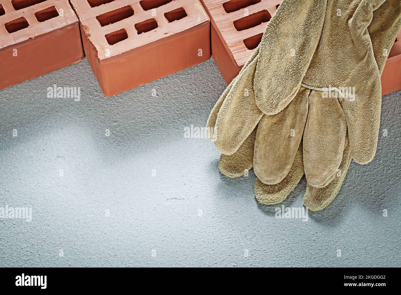 Building bricks safety gloves on concrete background construction ...