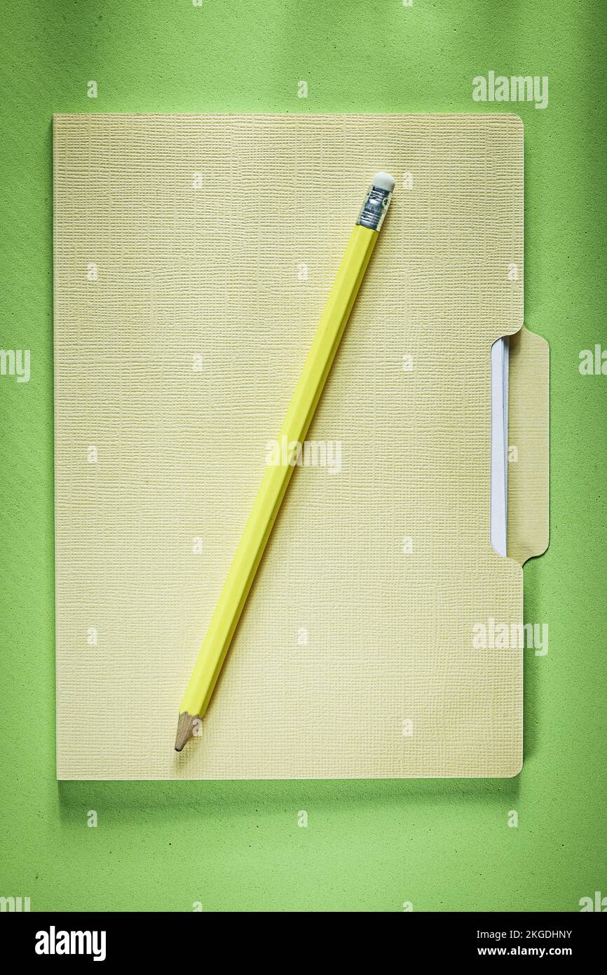Cardboard office folder pencil on green background Stock Photo - Alamy