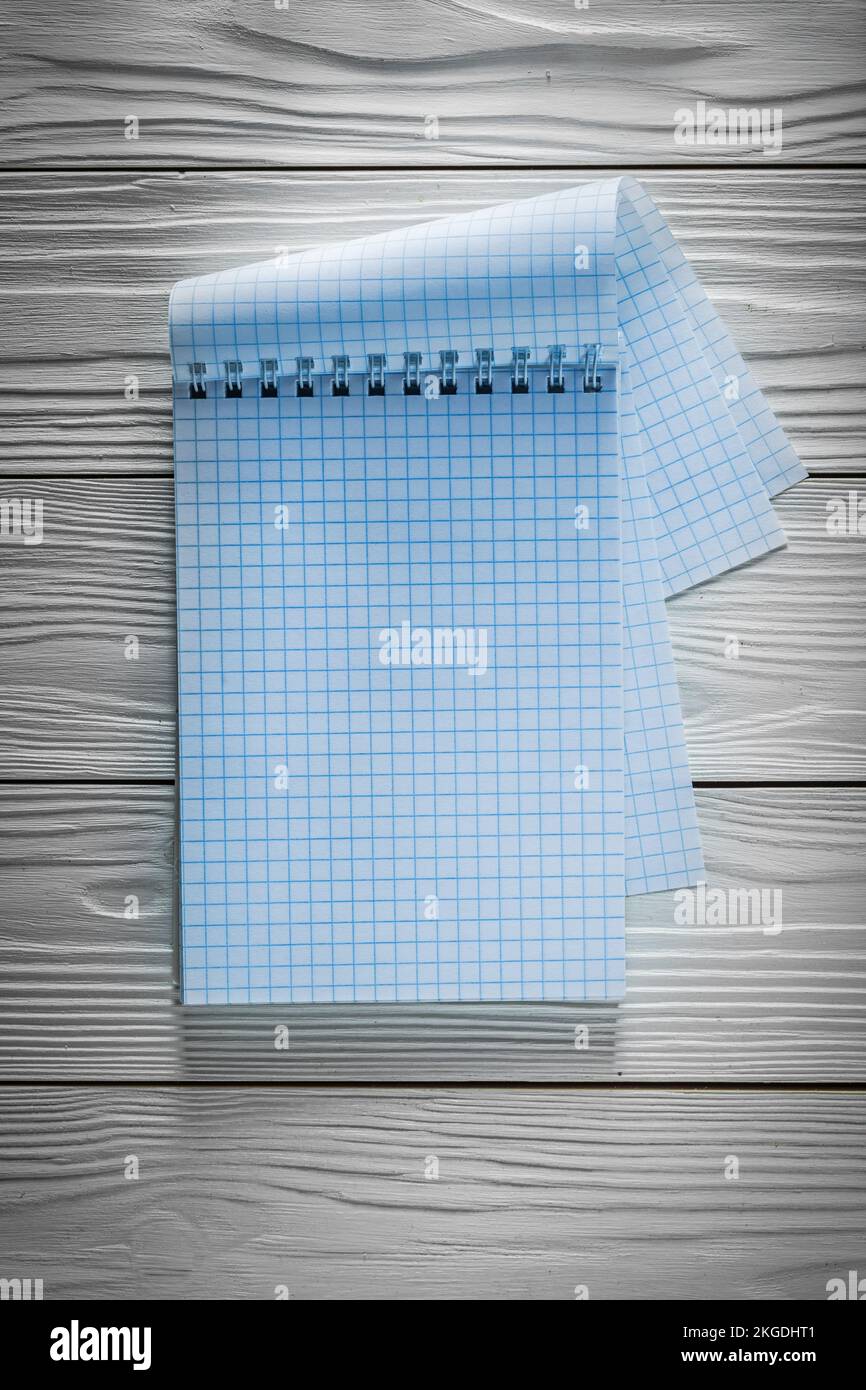 Checked notepad on white wooden board Stock Photo - Alamy