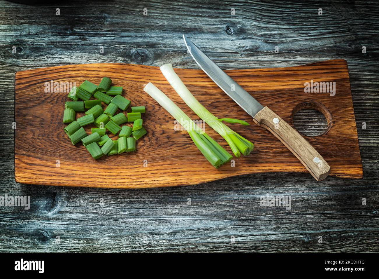 chopped onion stems and kitchen knife on wooden copping board vintage ...