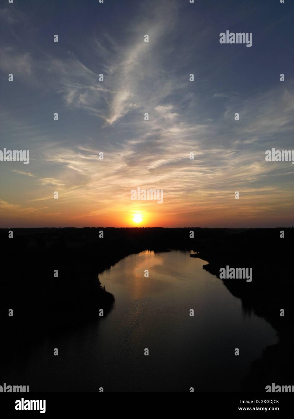 The vertical coastline silhouette under a blue and orange-shaded sunset ...