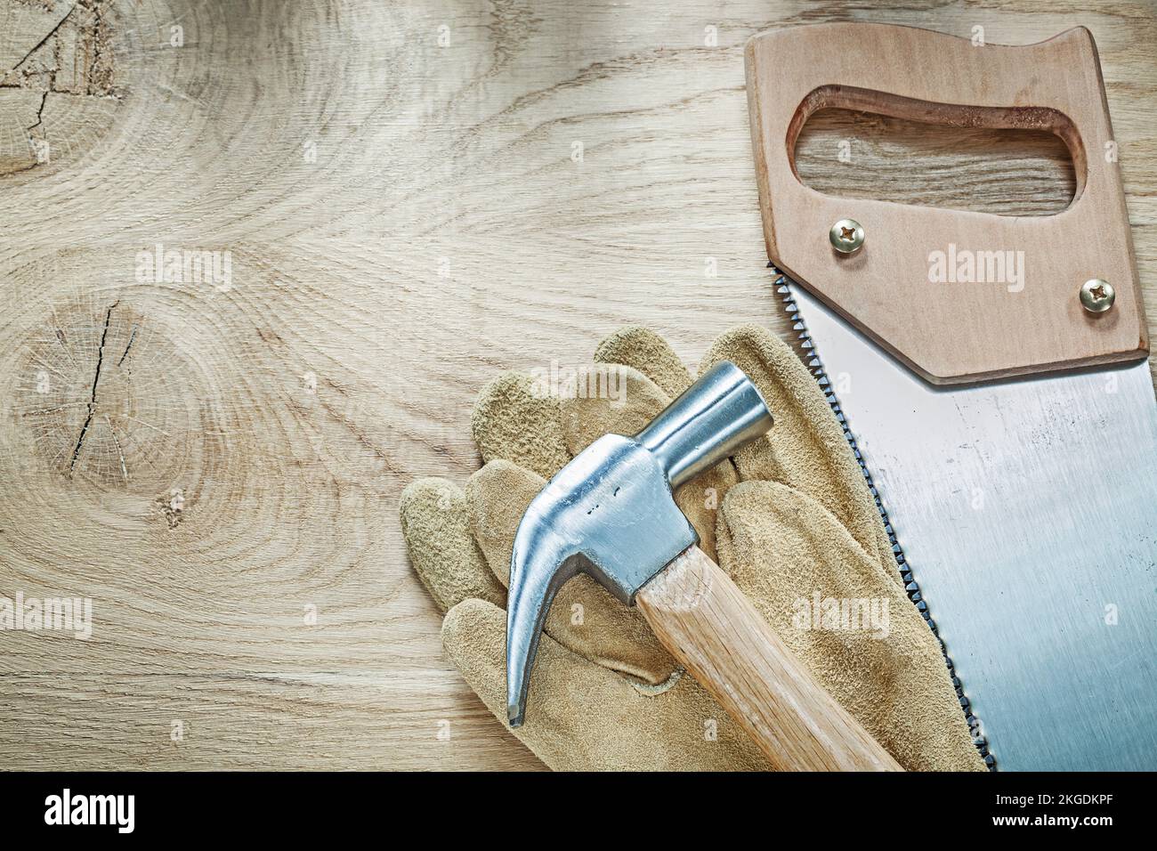 Claw hammer leather safety gloves stainless hacksaw on wooden board ...