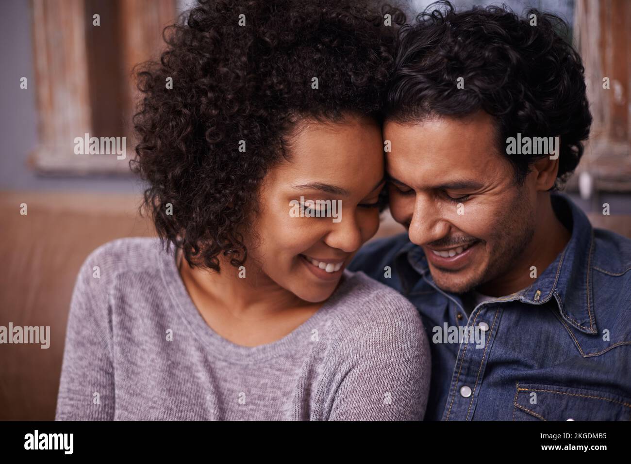 Feeling the love. a young couple sitting on a sofa at home Stock Photo ...