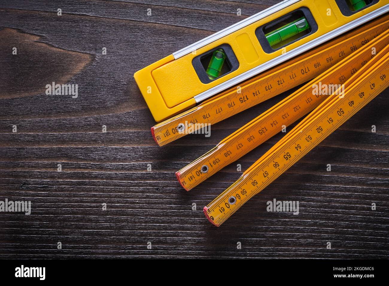 Close up of yellow construction level with wooden meter on vintage wood ...
