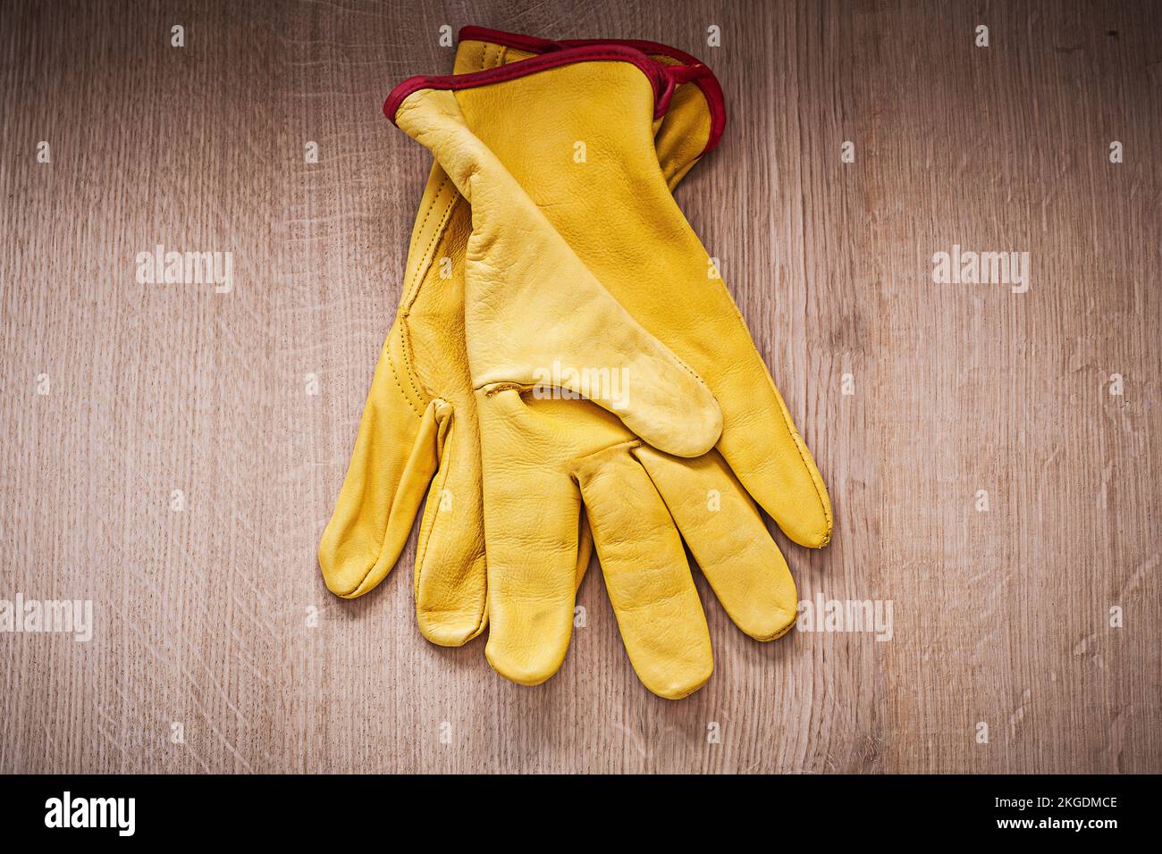 Close up image of agricultural leather safety gloves on wooden board ...