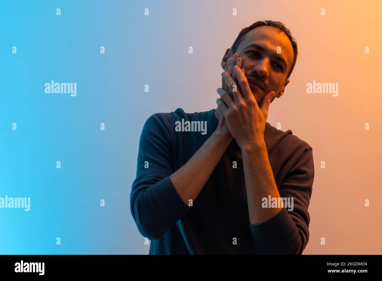 Tooth ache. Young man feeling pain, holding his cheek with both hands ...