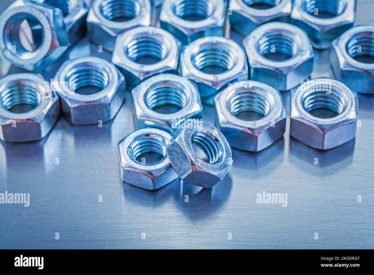Composition of stainless construction nuts on metallic background ...
