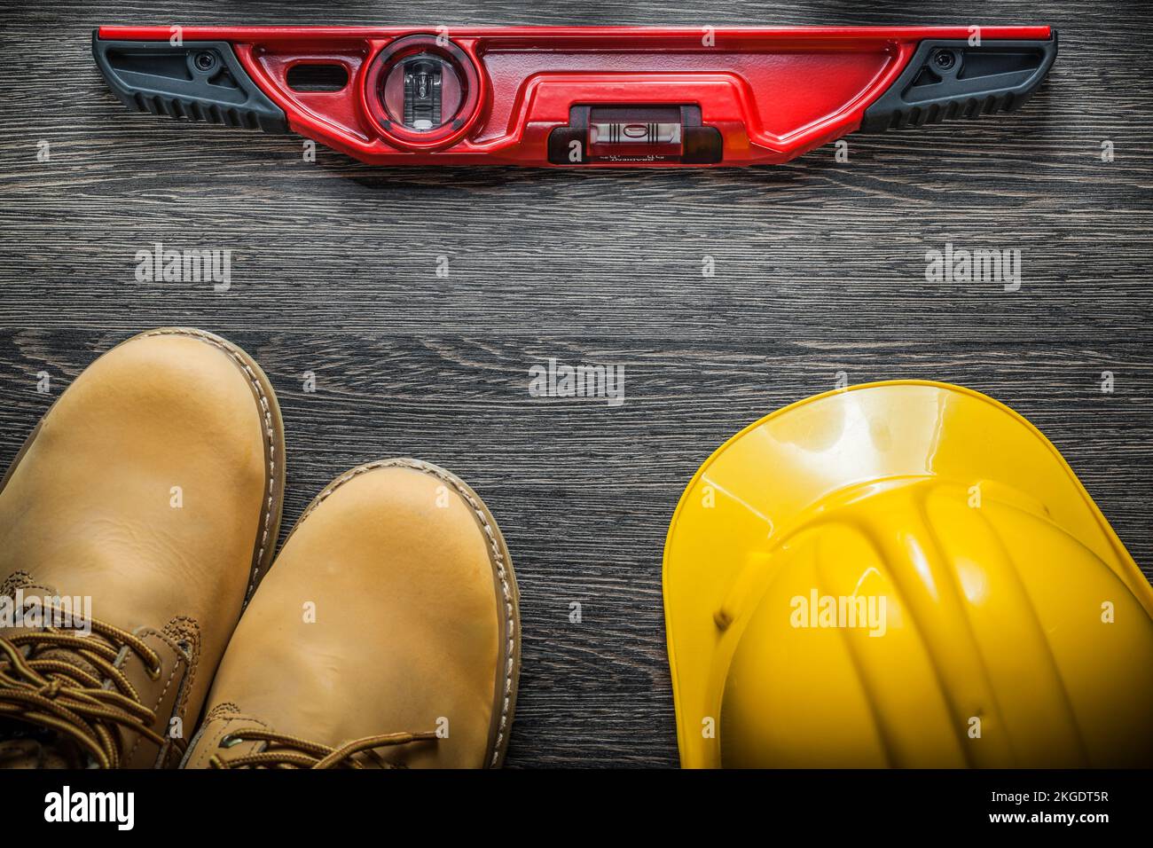 Construction level hard hat safety waterproof boots on wooden board ...