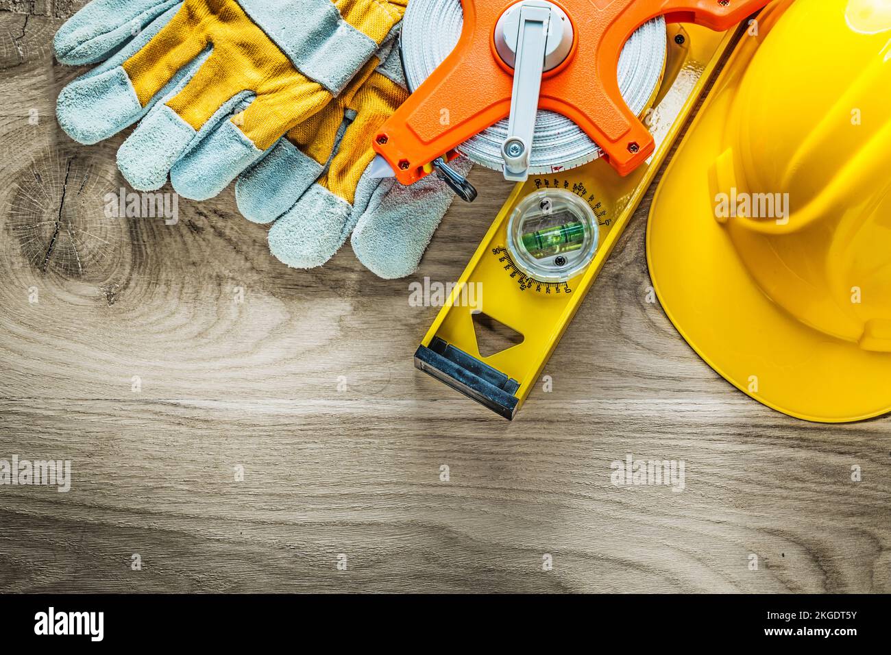 Construction level protective gloves measuring tape hard hat on wooden ...
