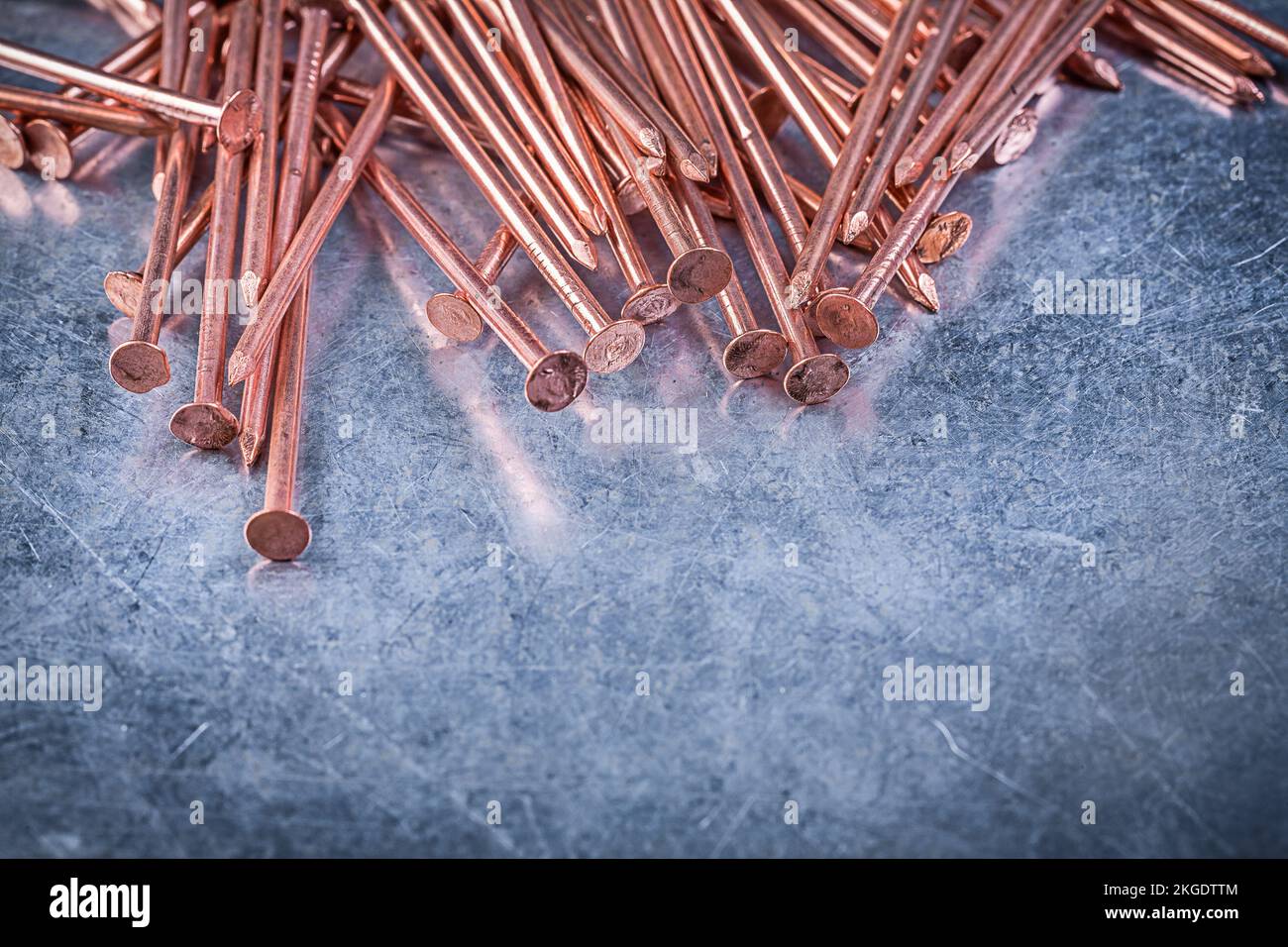 Copper construction nails on metallic background Stock Photo - Alamy