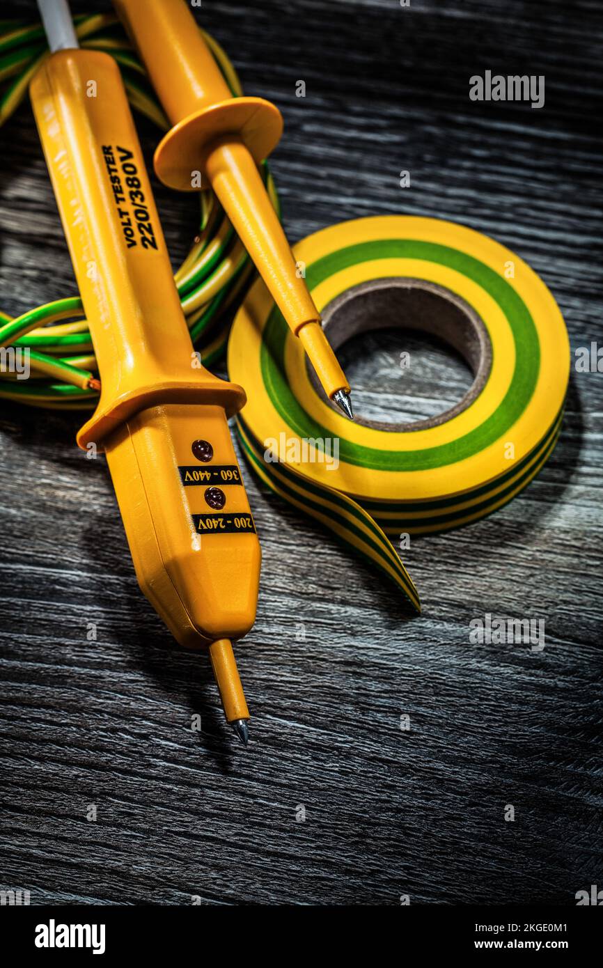 Electric tester hunk of cable insulating tape on vintage wooden board ...