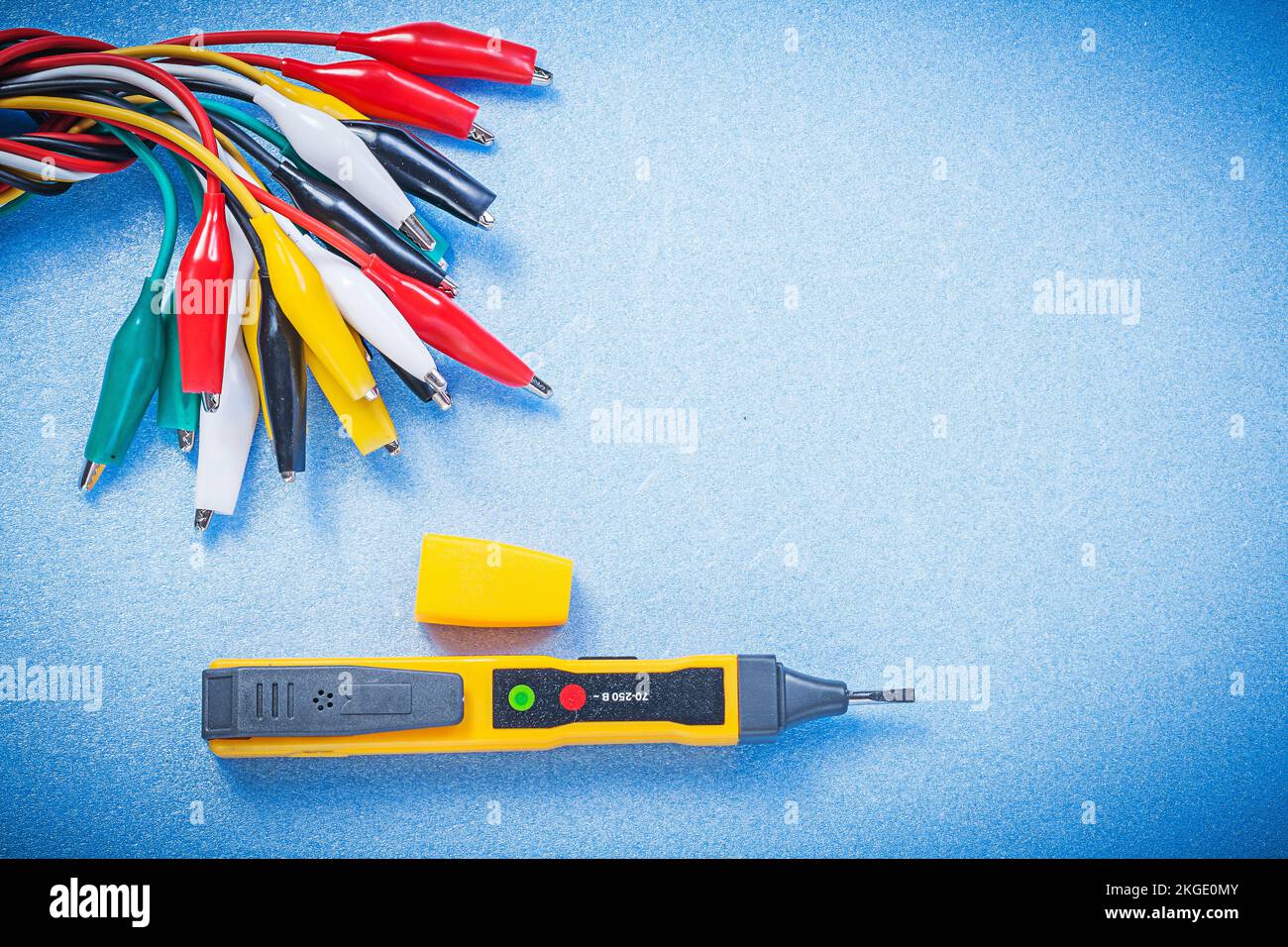 Electric tester indicator crocodile clip cables on blue background ...