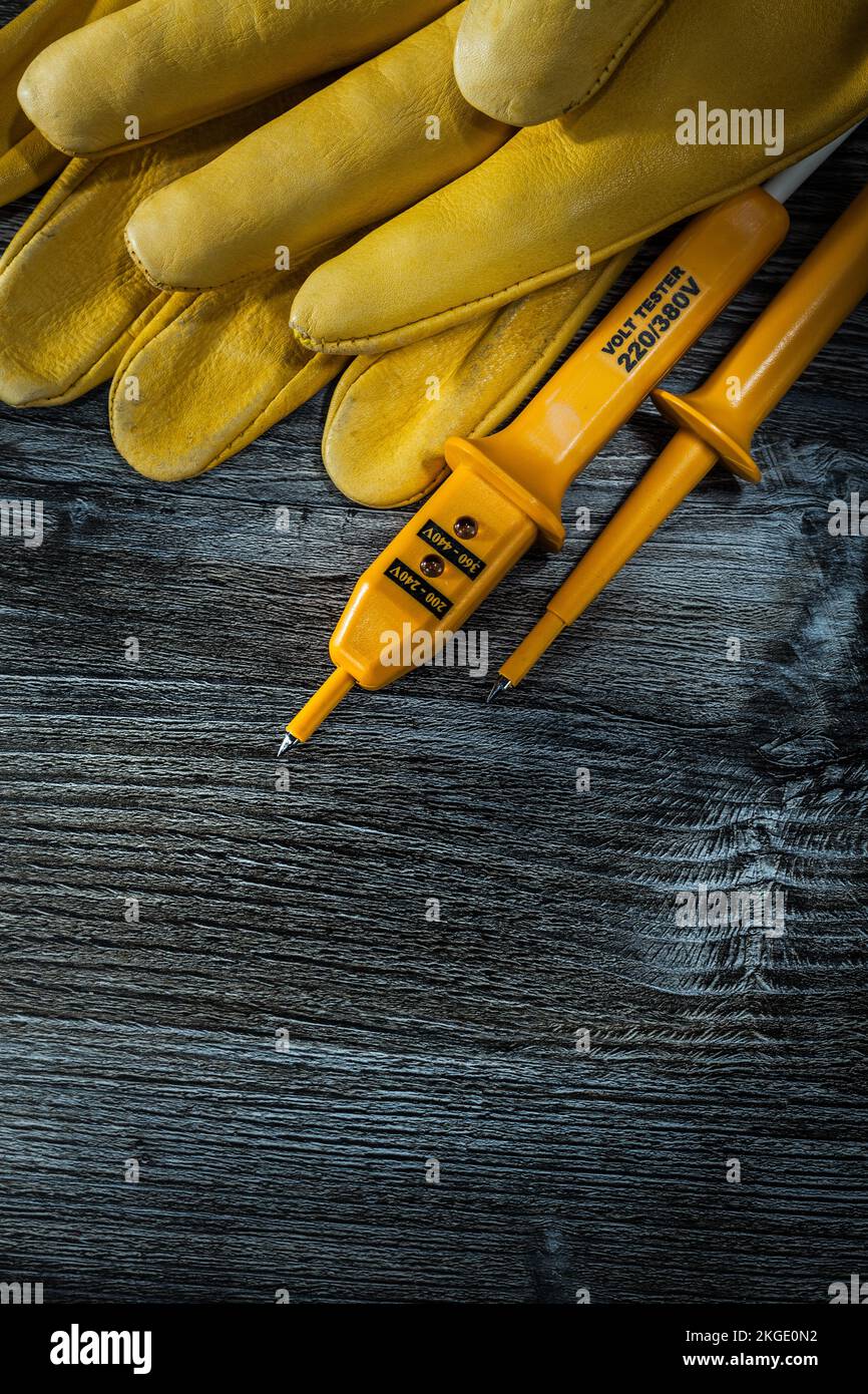 Electric tester pair of protective gloves on wooden board Stock Photo ...