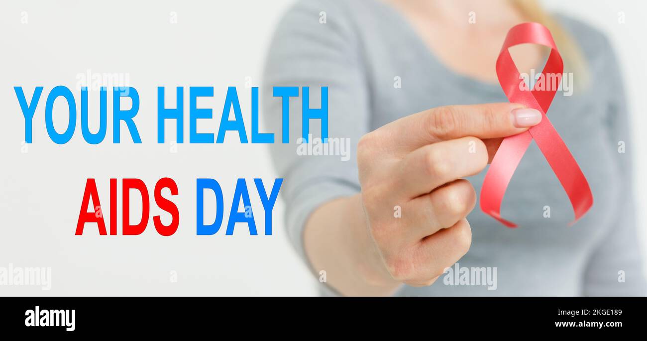 The hand is holding a red ribbon. AIDS awareness sign. World HIV Day ...