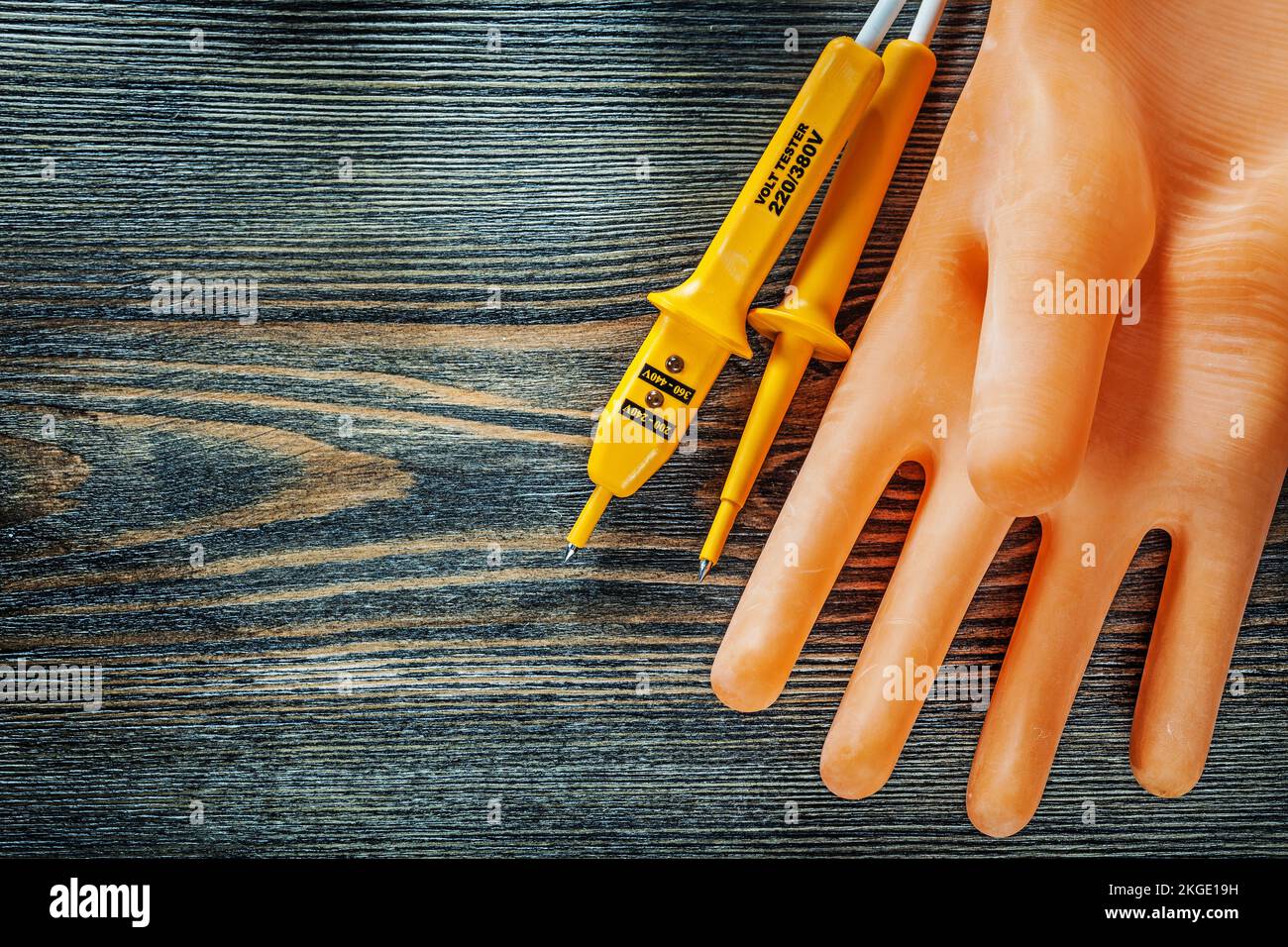 Electricians gloves electric tester on wooden board Stock Photo - Alamy