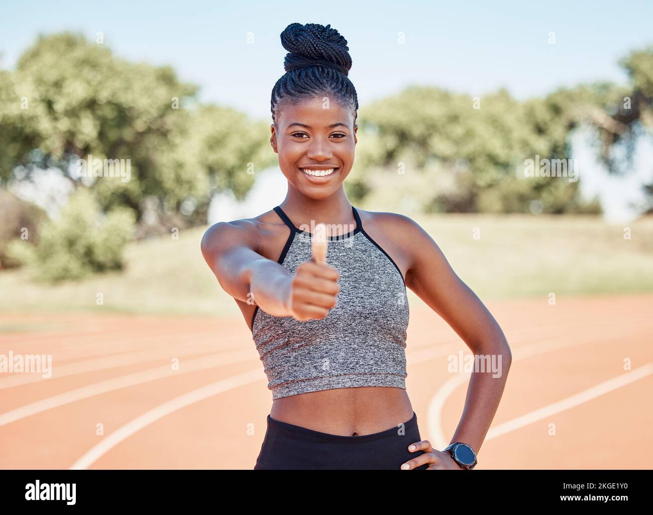 Runner, woman and thumbs up in portrait on track, field and outdoor for ...
