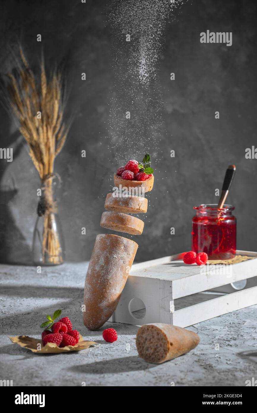 baguette bread with raspberry jam and sugar splashing with floating ...