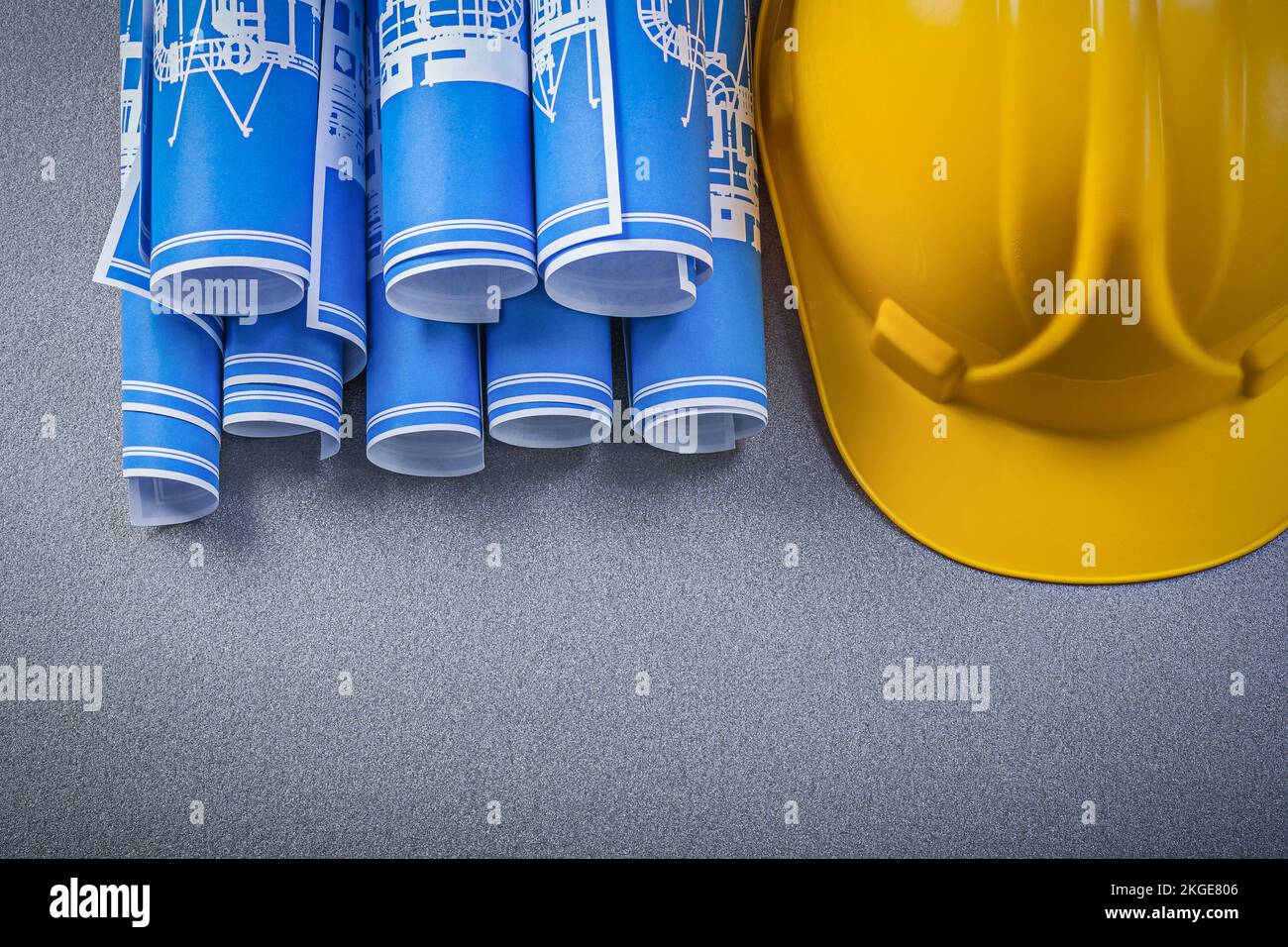 Hard hat blue rolled construction plans on grey background Stock Photo ...