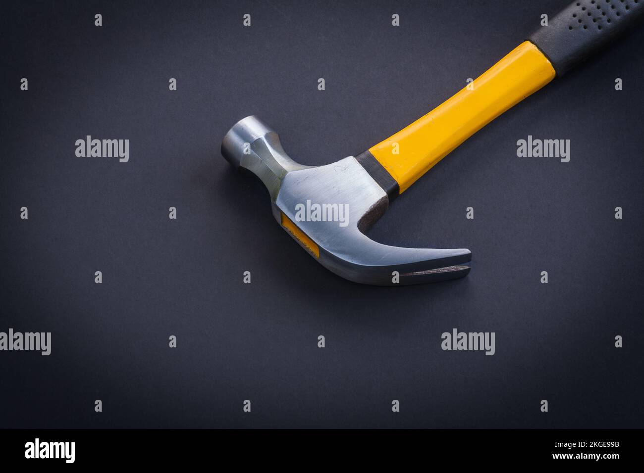 horizontal view very close up view claw hammer with yellow and rubber ...