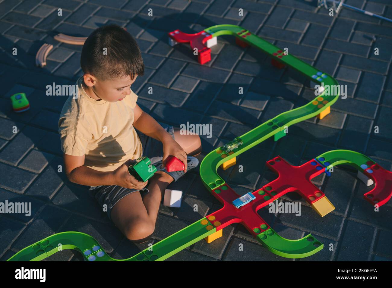 Adorable little kid boy playing outdoors with colorful plastic blocks ...