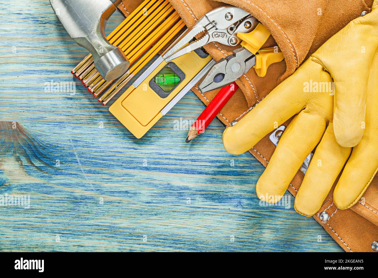 Leather construction belt with working tools on wooden board ...