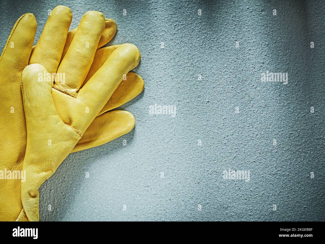 Leather protective gloves on concrete surface construction concept ...