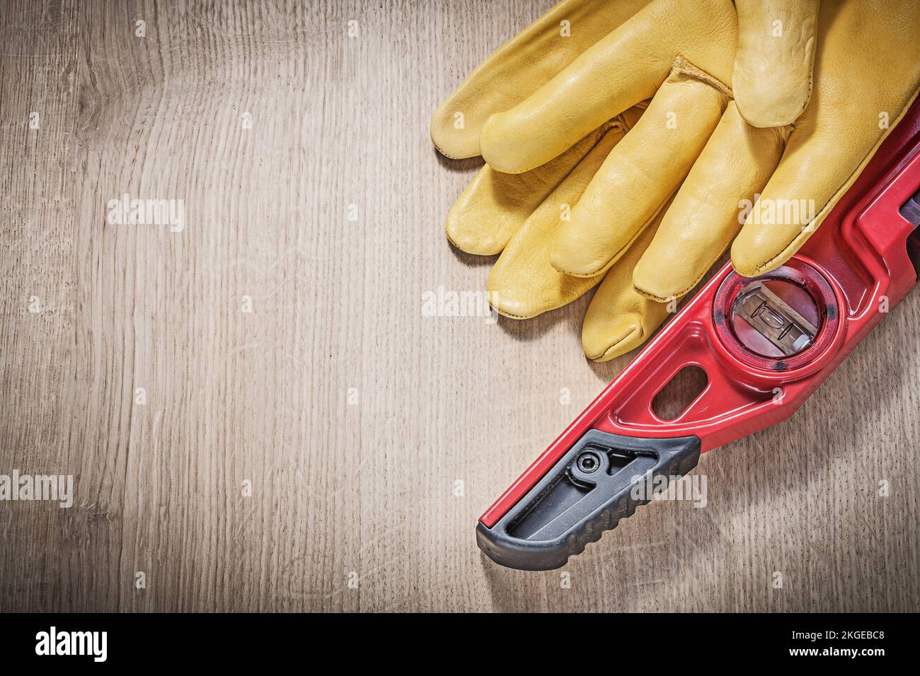 Leather safety gloves construction level on wooden board Stock Photo ...