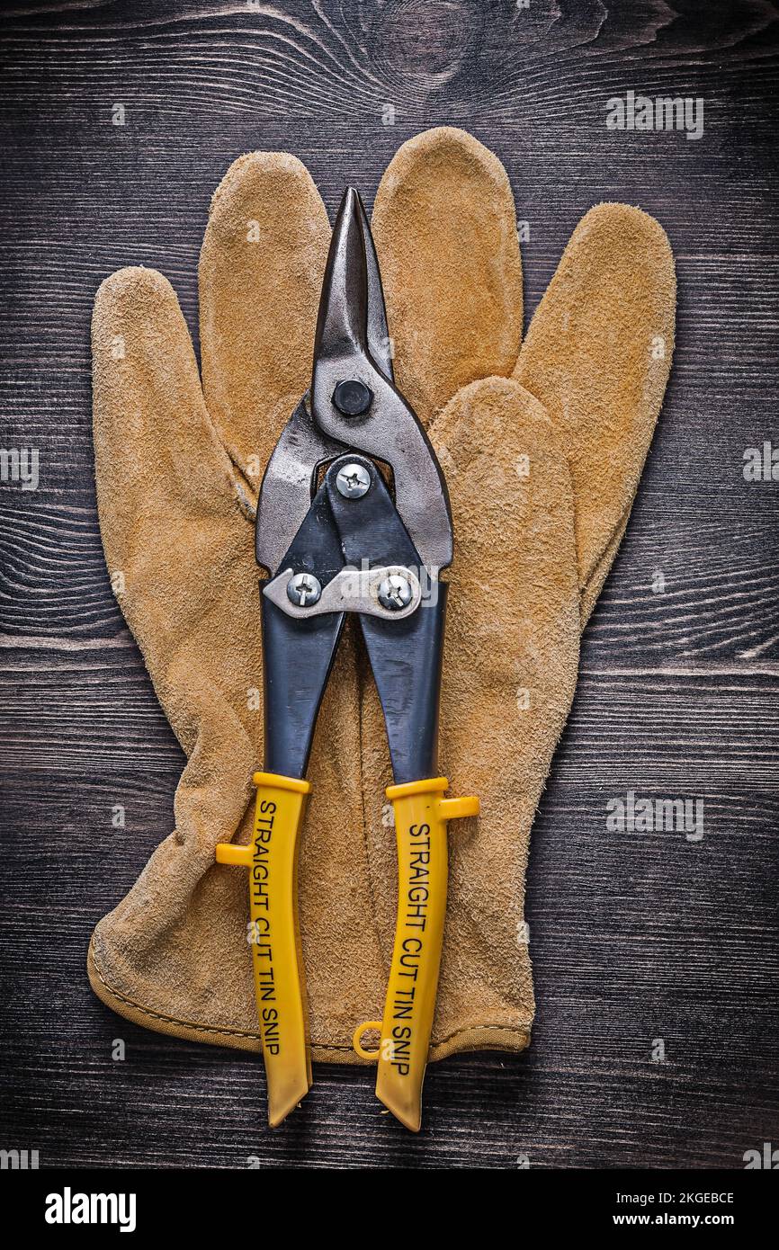 Leather safety glove wire cutter on wood board construction concept ...