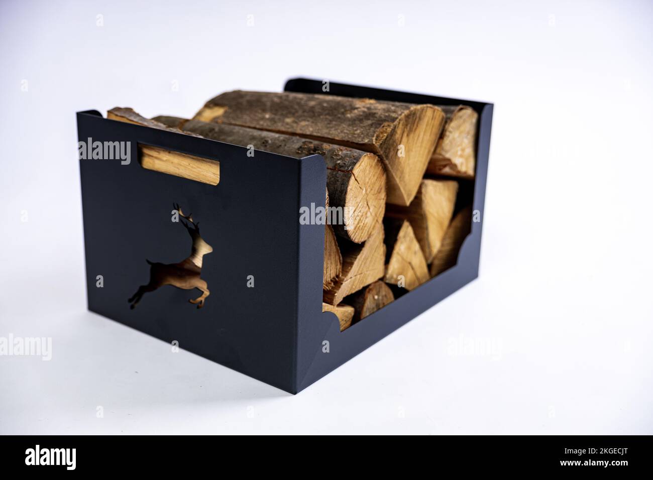 A metal box for firewood with wood logs in it on white background in a ...