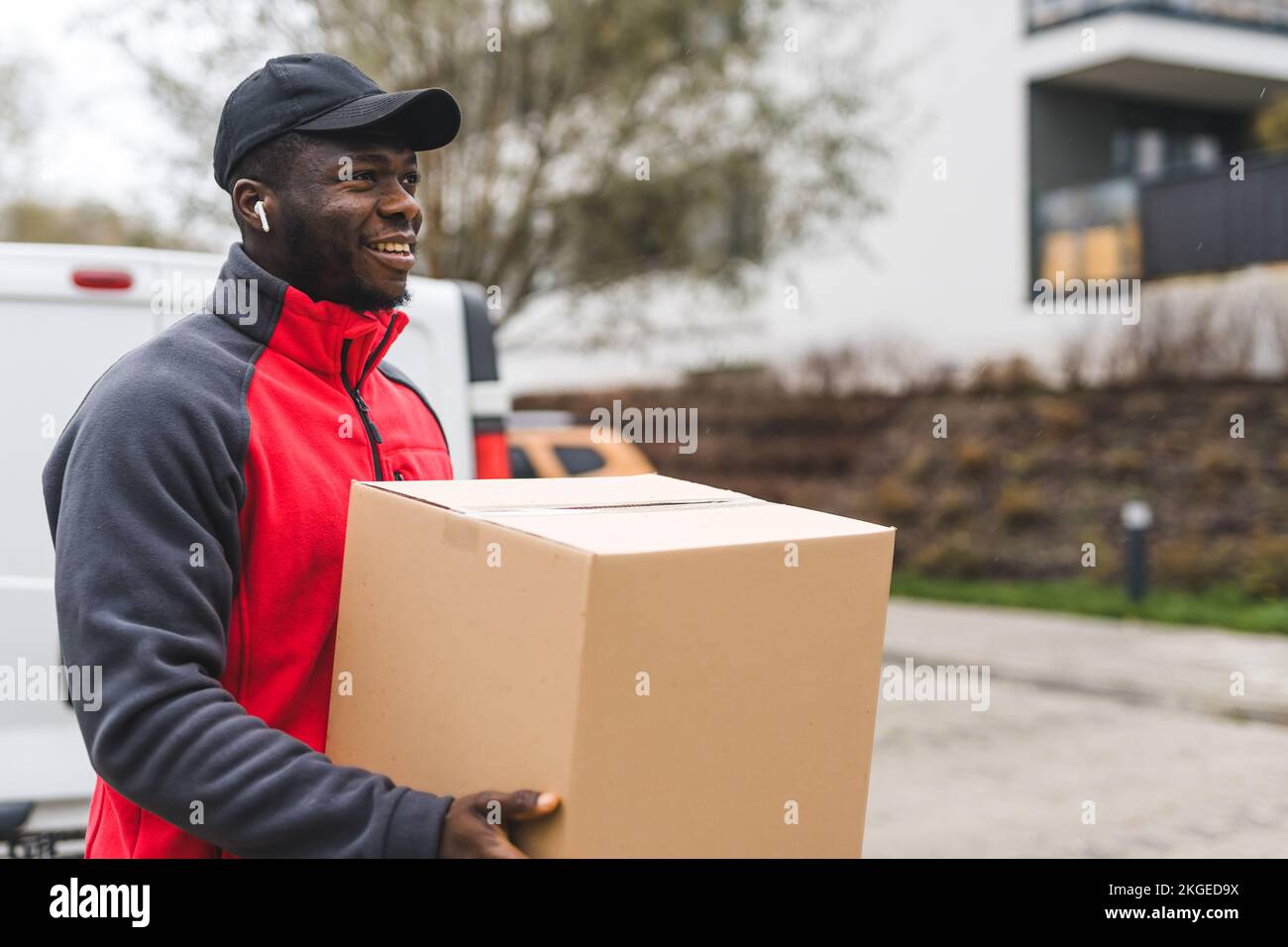 Black young adult man wearing work uniform red pullover smiling ...