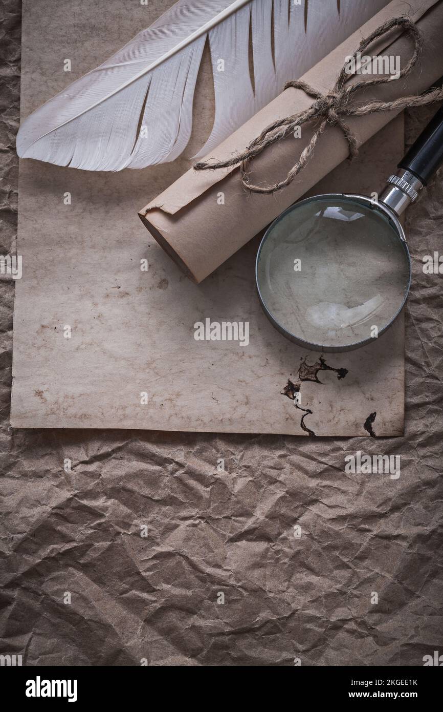 Medieval sheet feather loupe rolled document on messy crumpled paper ...