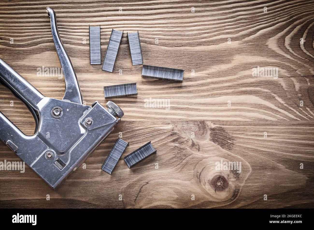 Metal stapler gun staples on wood board construction concept Stock ...