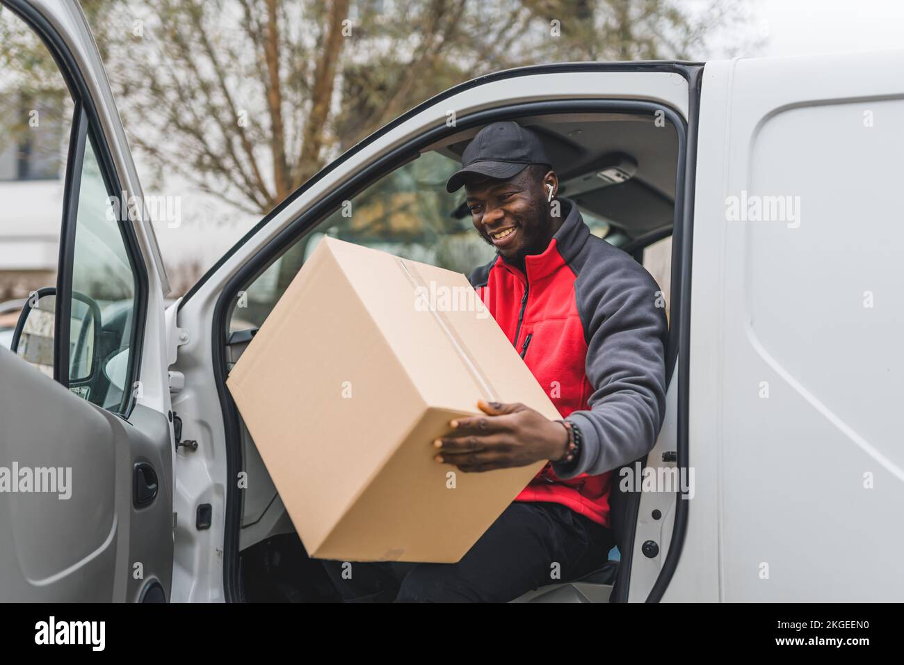 Black delivery man holding package hi-res stock photography and images ...